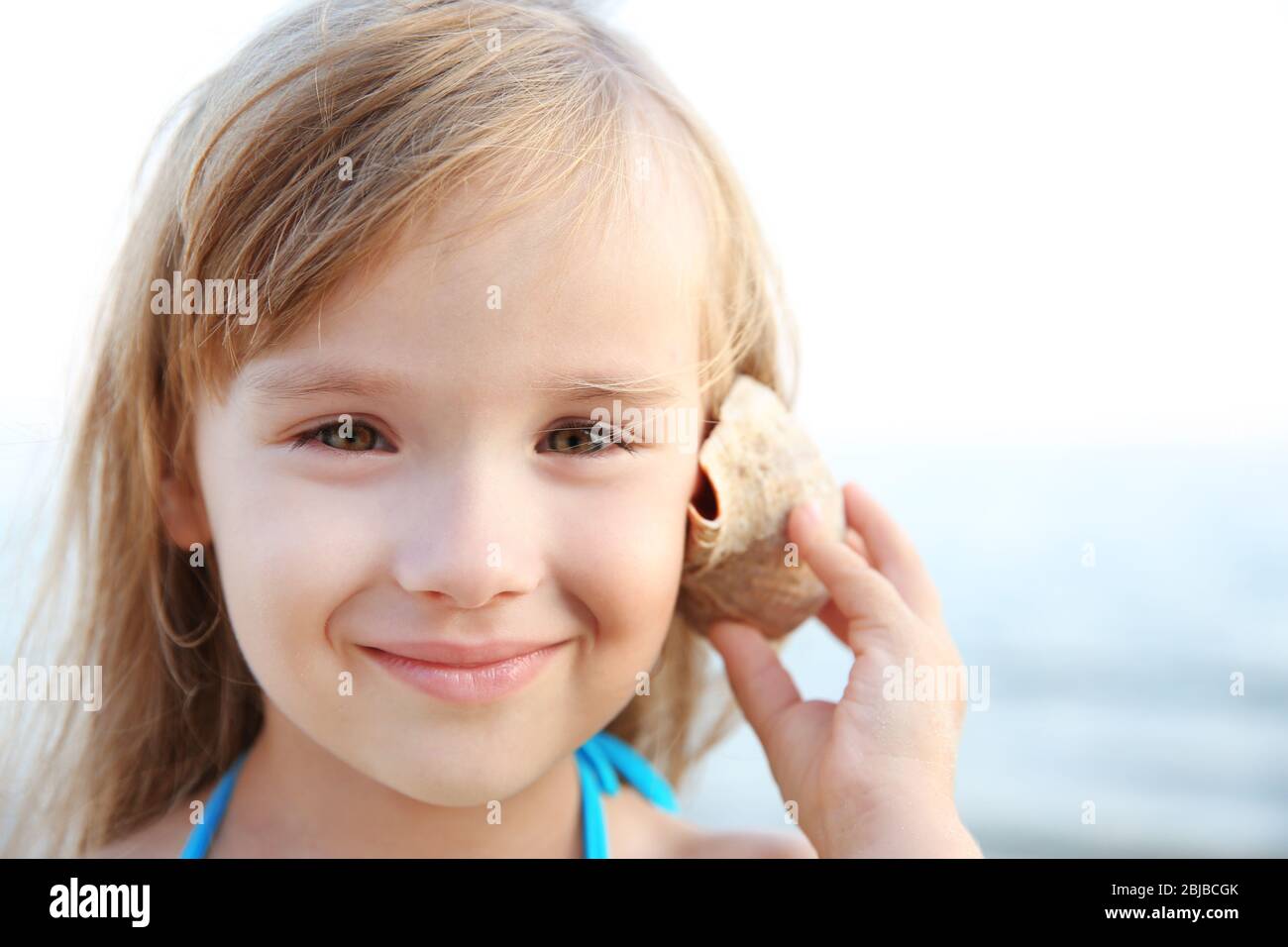 Little girl with seashell hi-res stock photography and images - Alamy