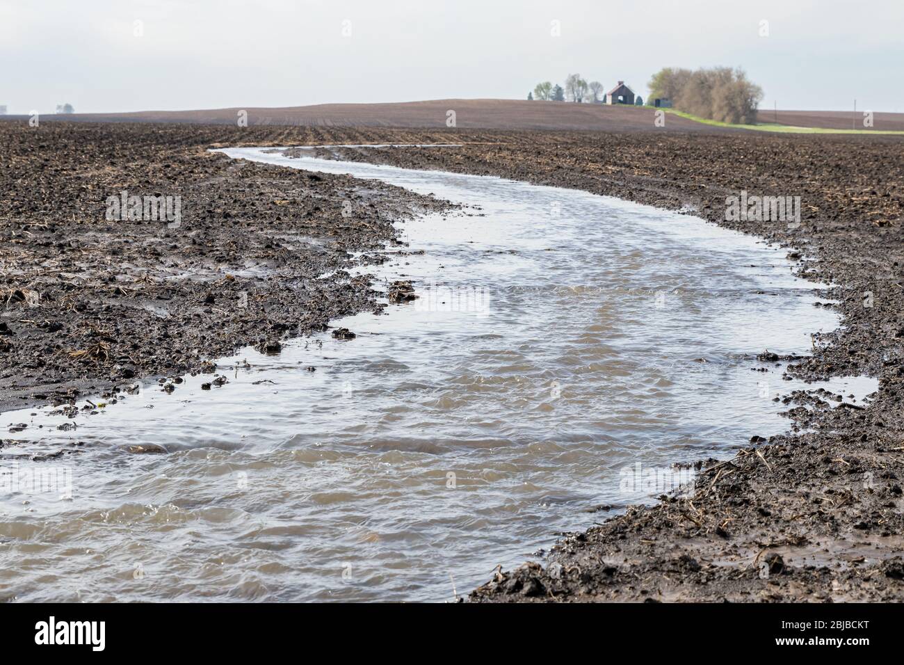 water flowing in farm field after heavy spring rains and storms brought ...