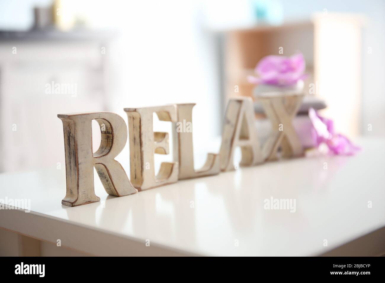 Wooden word RELAX with flowers on light background Stock Photo - Alamy
