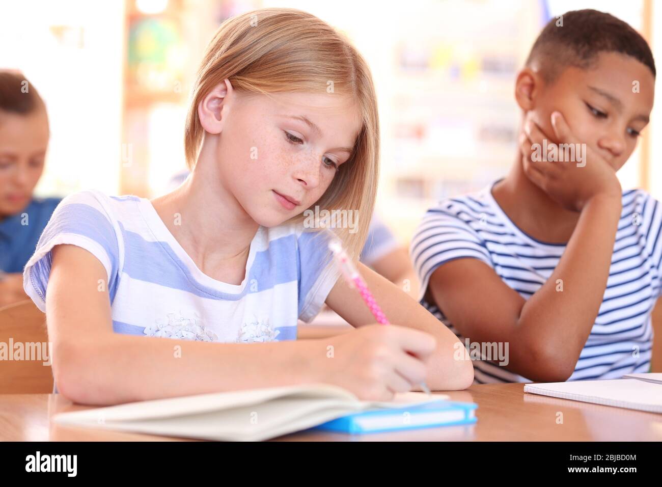 Cute schoolgirl on lesson in classroom Stock Photo - Alamy