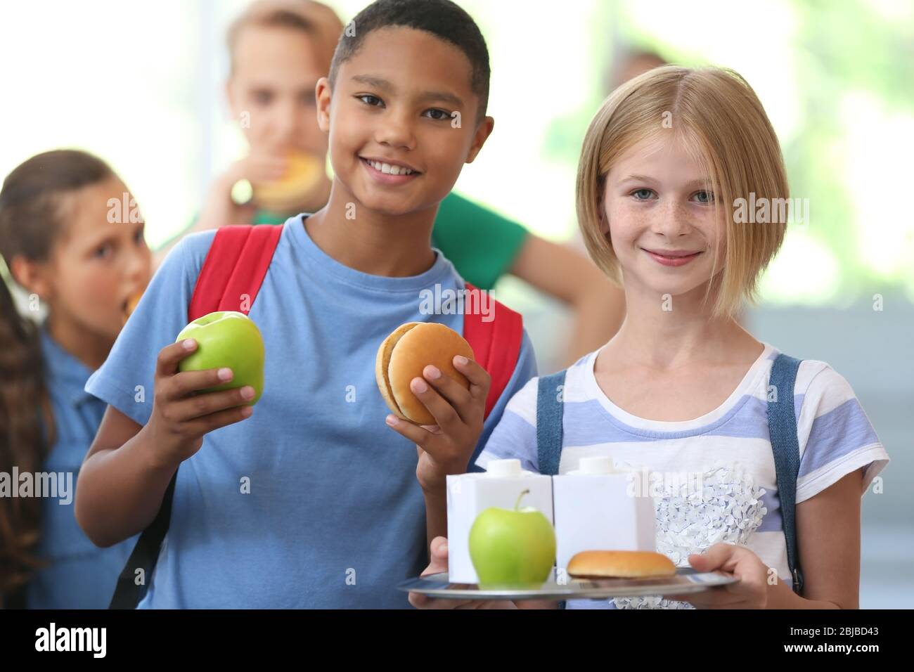 Cute kids eating in school Stock Photo - Alamy