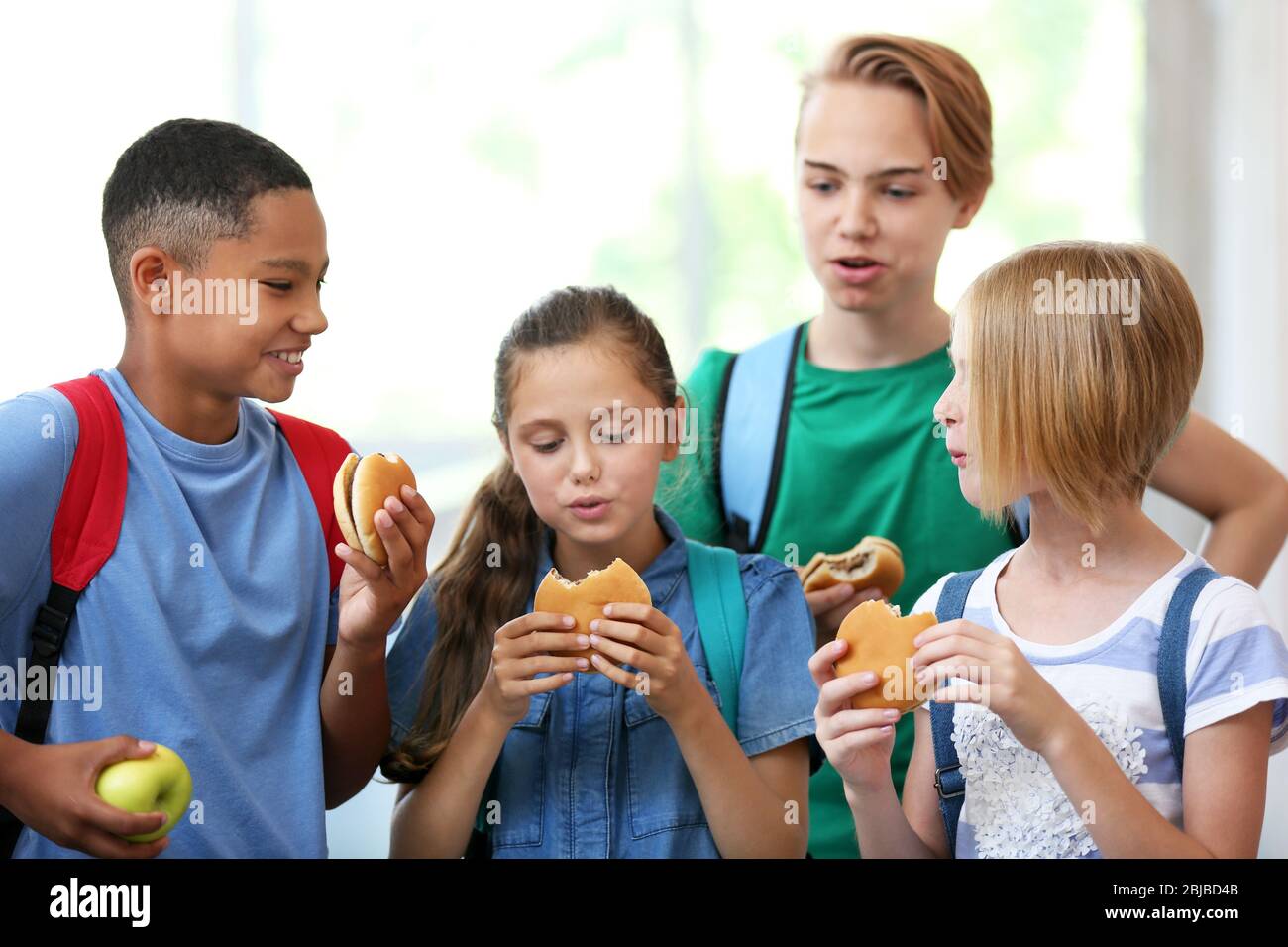 Cute kids eating in school Stock Photo - Alamy