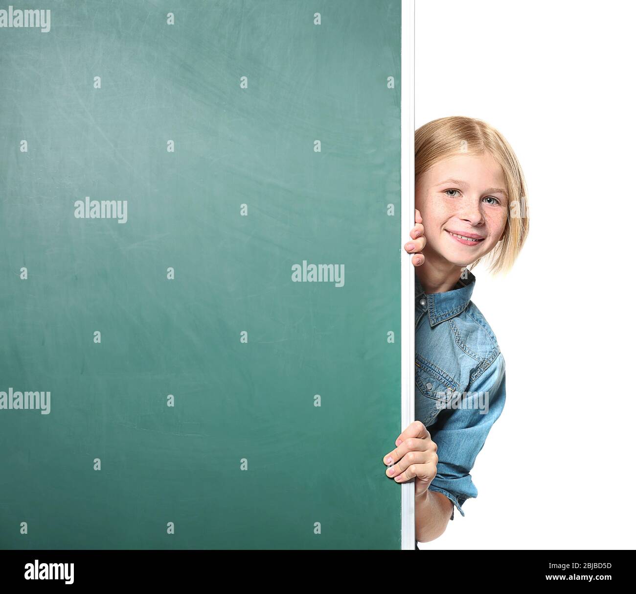 Cute girl near chalkboard on light background Stock Photo - Alamy