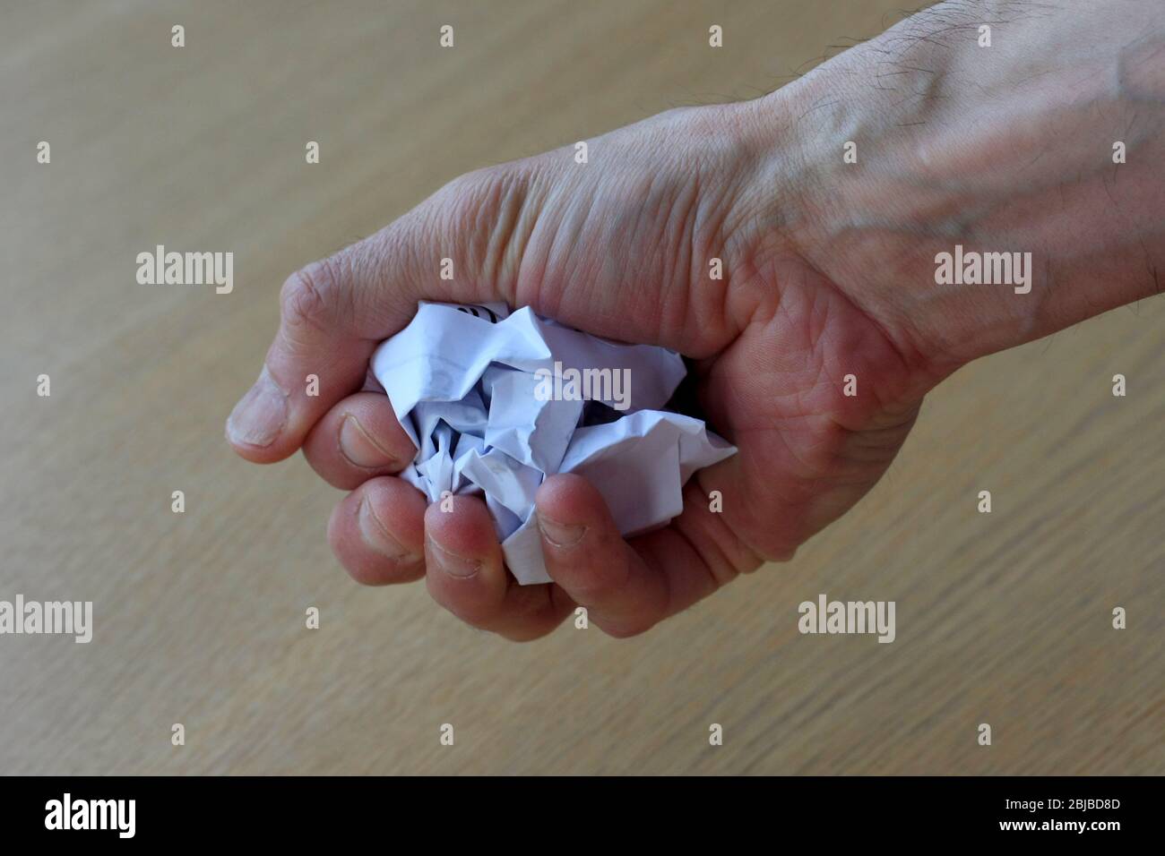Male squeezing a paper ball Stock Photo - Alamy
