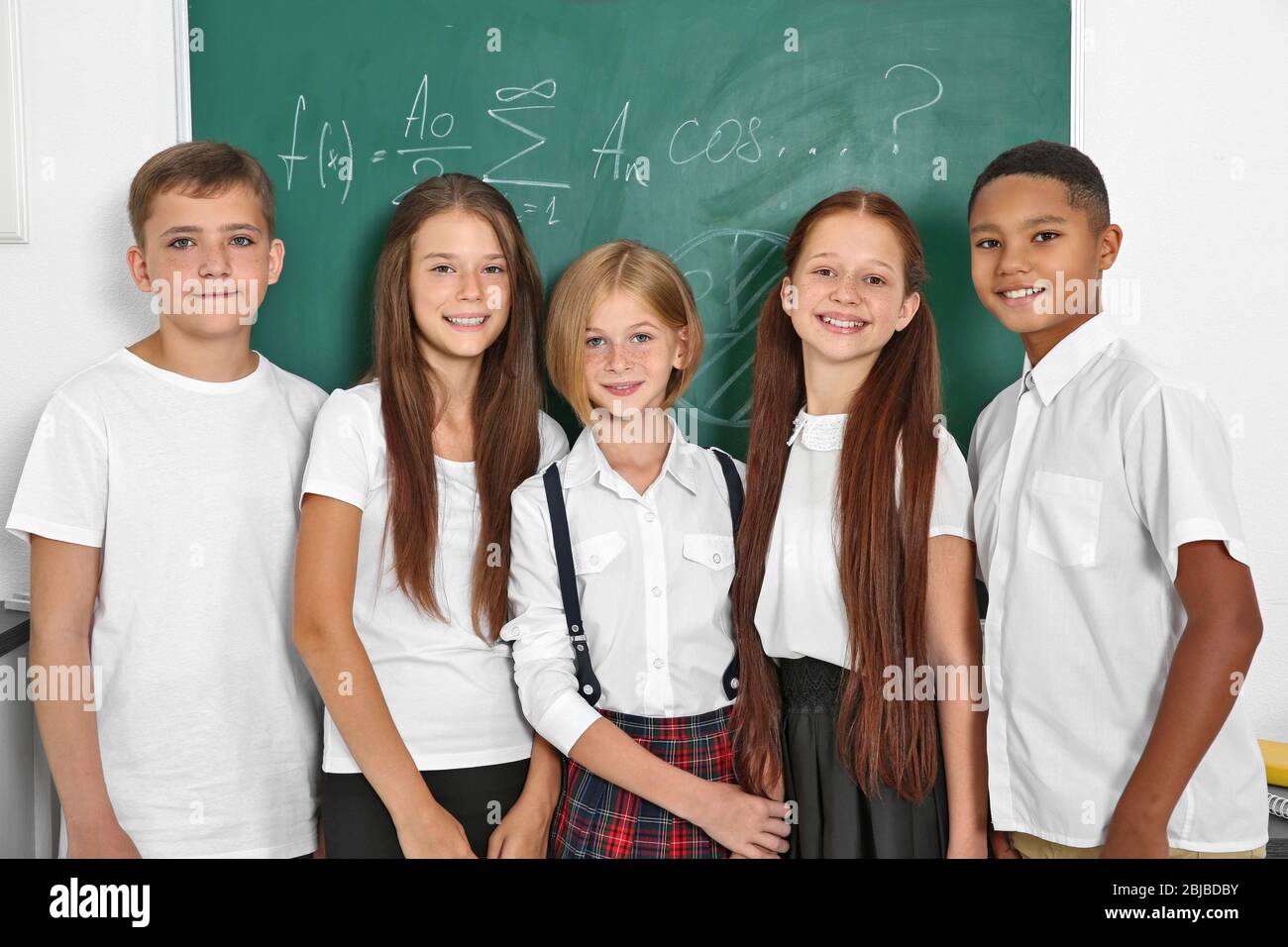 Schoolchildren standing in classroom near blackboard Stock Photo - Alamy