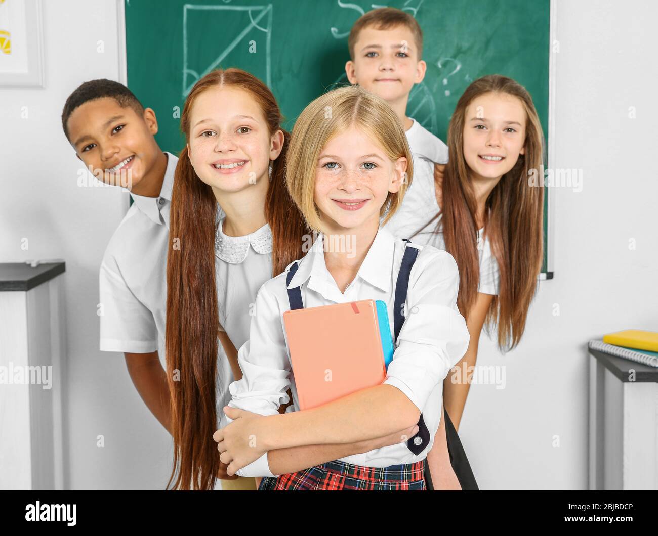 Schoolchildren standing in classroom near blackboard Stock Photo - Alamy
