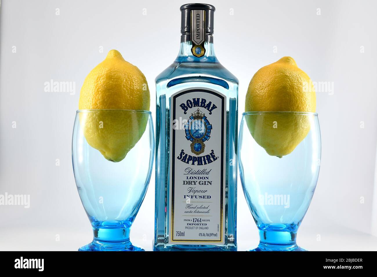 Bottle of Bombay Sapphire gin with two goblets and lemons white ...