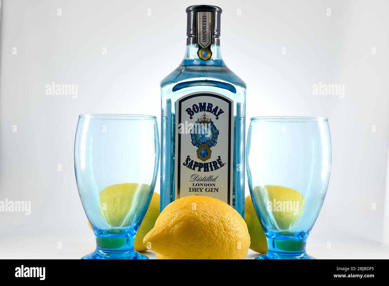 Bottle of Bombay Sapphire gin with two goblets and lemons white ...