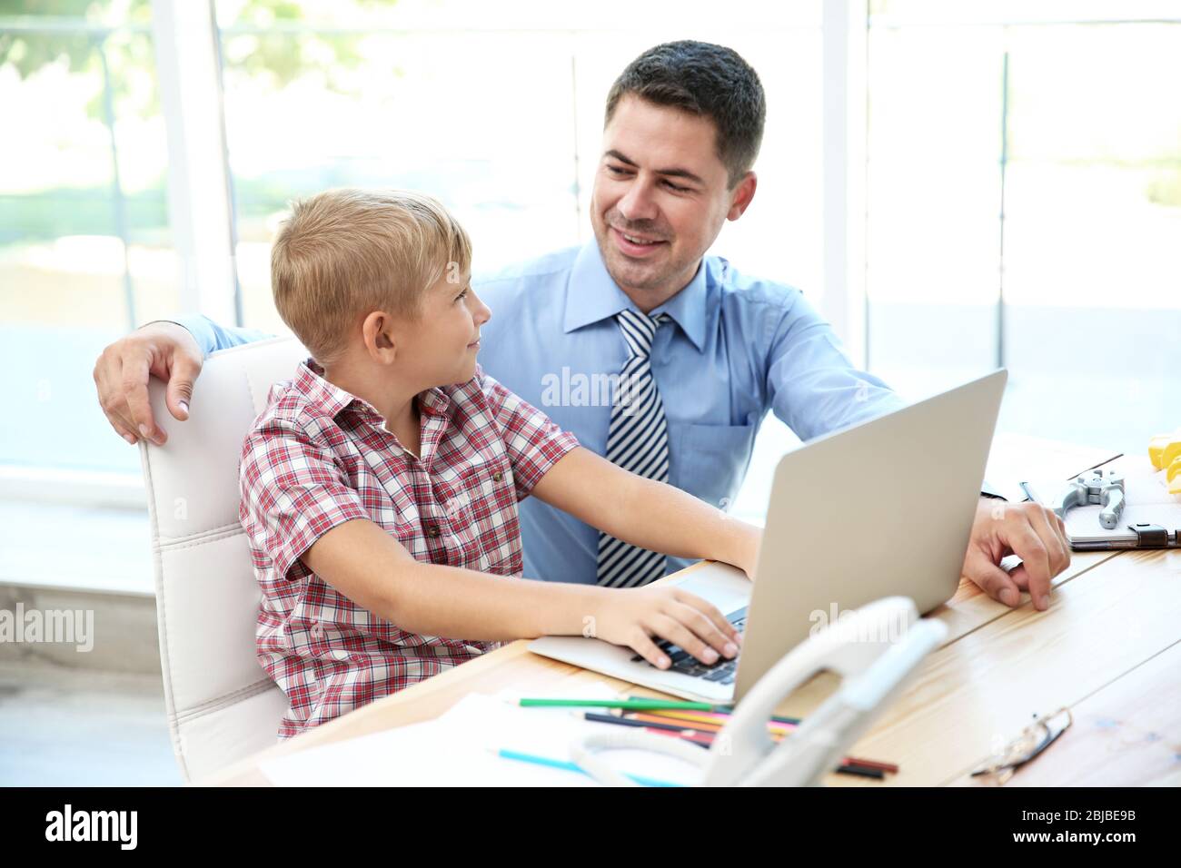 Little boy and father working at office Stock Photo - Alamy