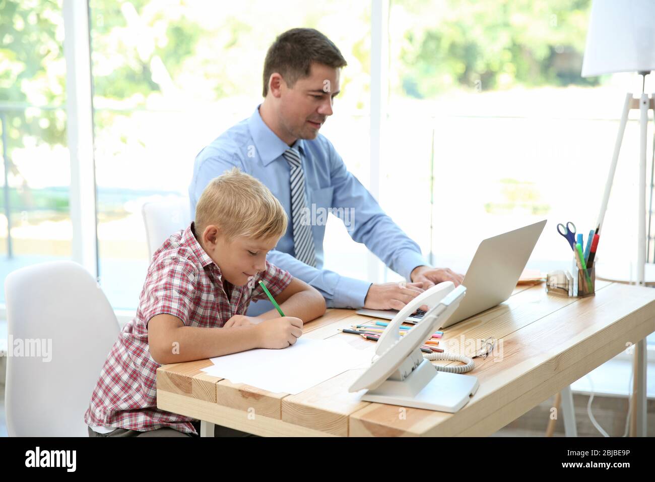 Little boy and father working at office Stock Photo - Alamy