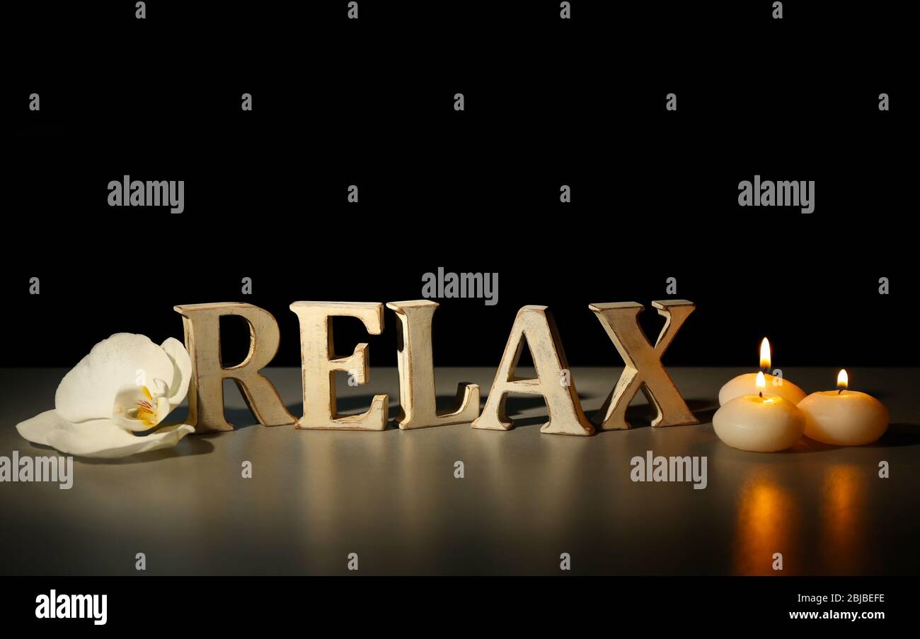 Word RELAX of wooden letters on table and black background Stock Photo ...