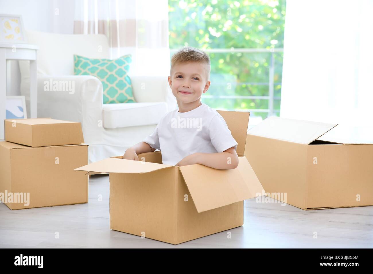 Little cute boy playing with cardboard boxes at home Stock Photo - Alamy
