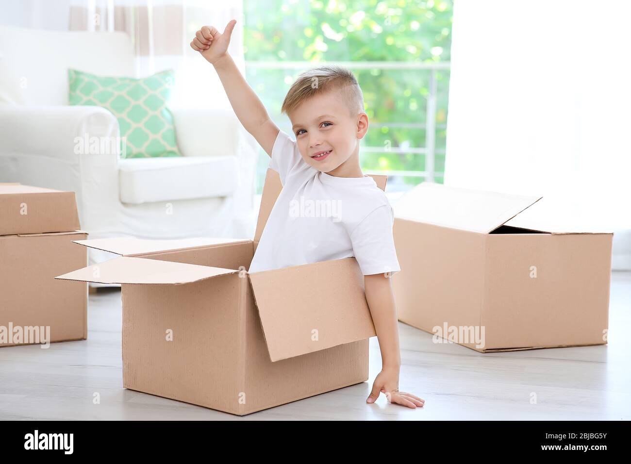Little cute boy playing with cardboard boxes at home Stock Photo - Alamy