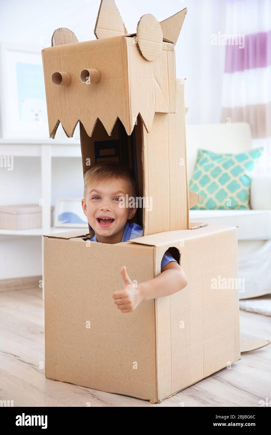Little boy playing with cardboard box indoors Stock Photo - Alamy