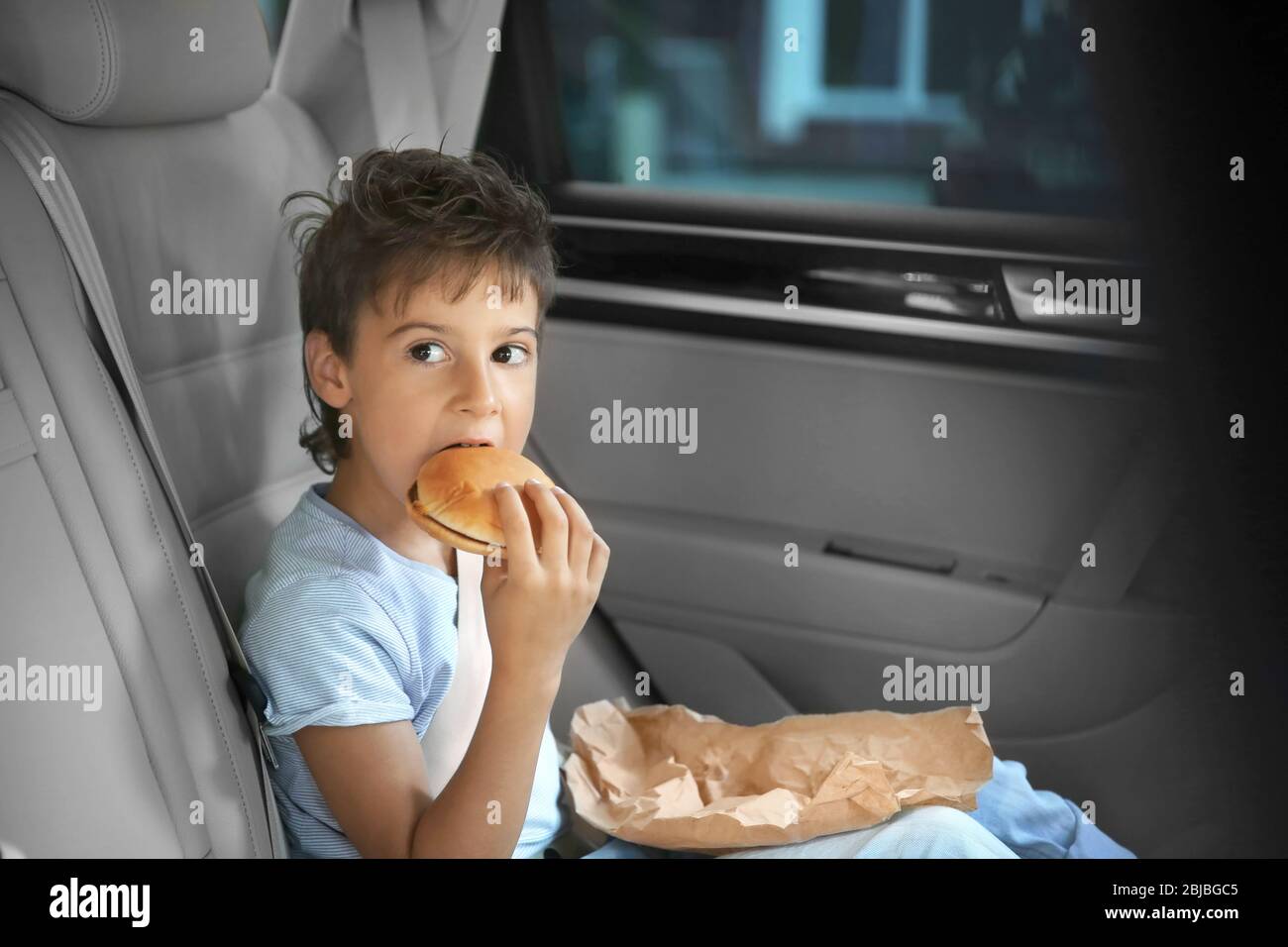 Boy eating in car Stock Photo - Alamy