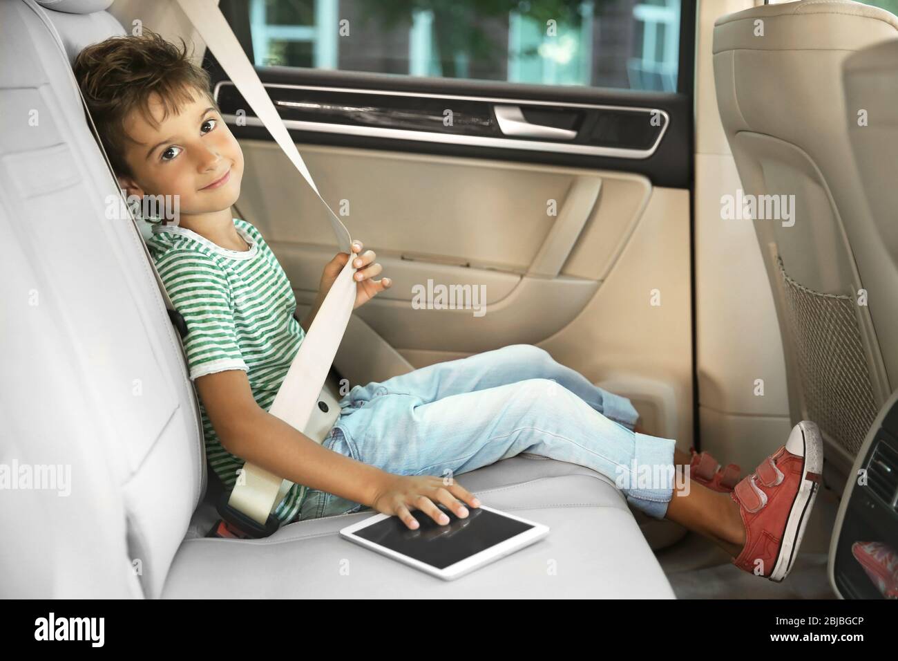 Boy playing with tablet in car Stock Photo - Alamy