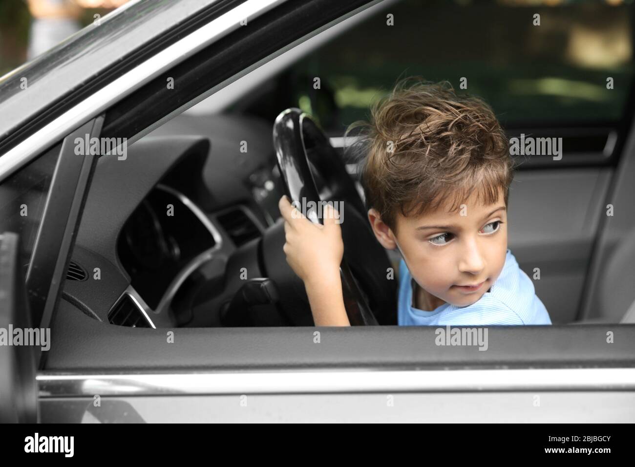 Boy driving parent car Stock Photo - Alamy