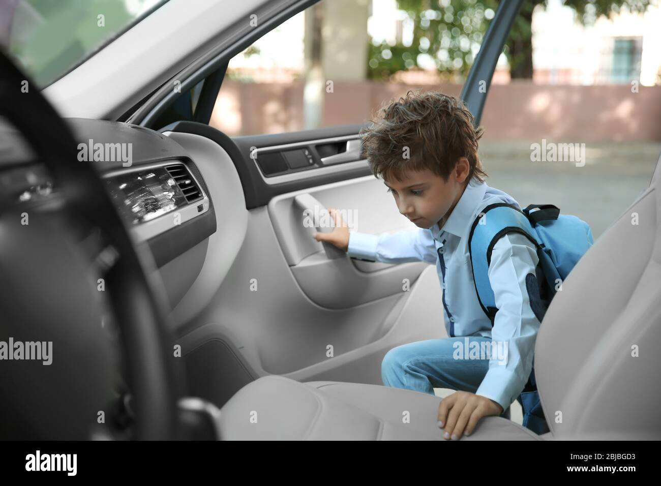 Taking pupil after school. Boy getting in car Stock Photo - Alamy