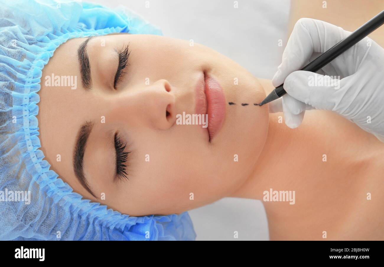 Plastic surgery concept. Hand in glove marking women face Stock Photo ...