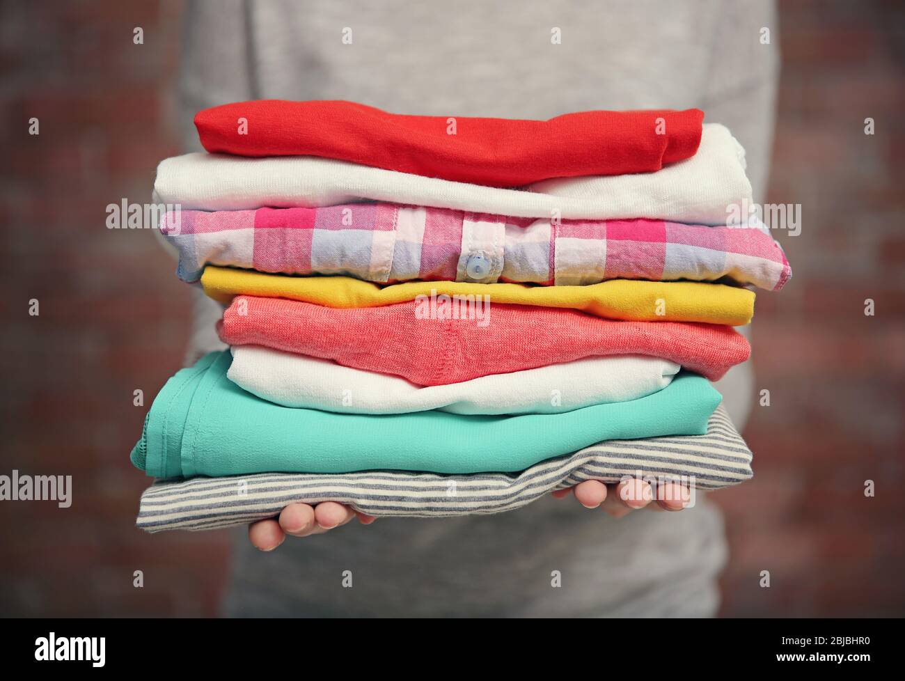 Holding fold clothes hi-res stock photography and images - Alamy