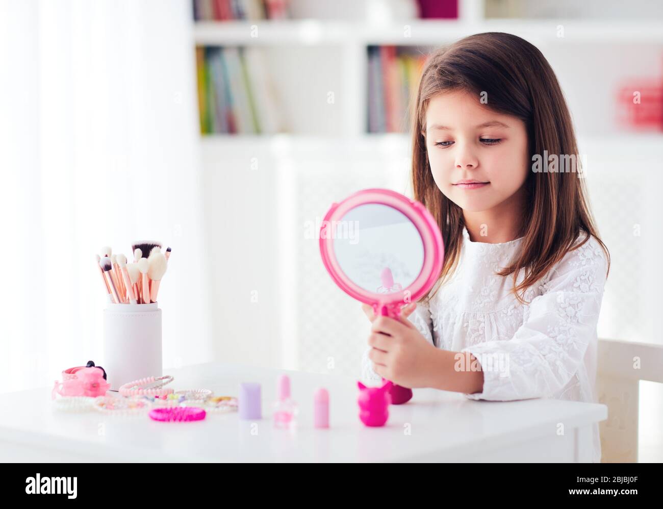 beautiful young girl, kid applying makeup, toy beauty set Stock Photo ...