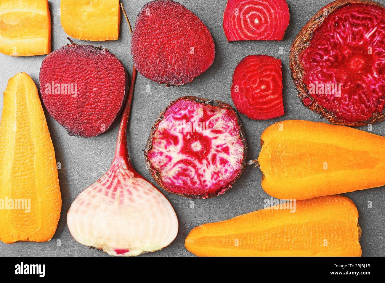 Fresh young sliced beets and carrots on grey background Stock Photo - Alamy