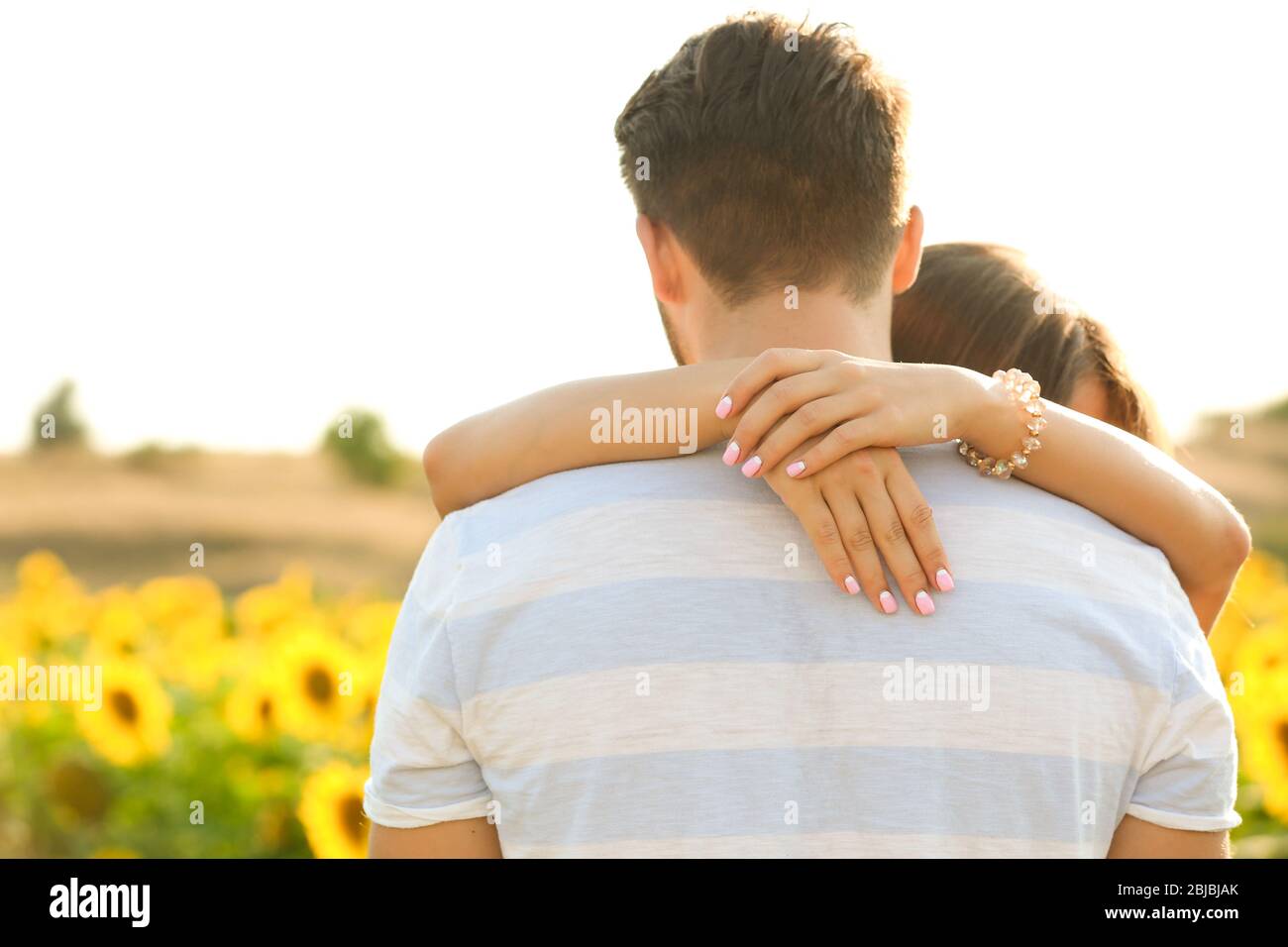 Young man standing back and girl hugging his neck Stock Photo - Alamy