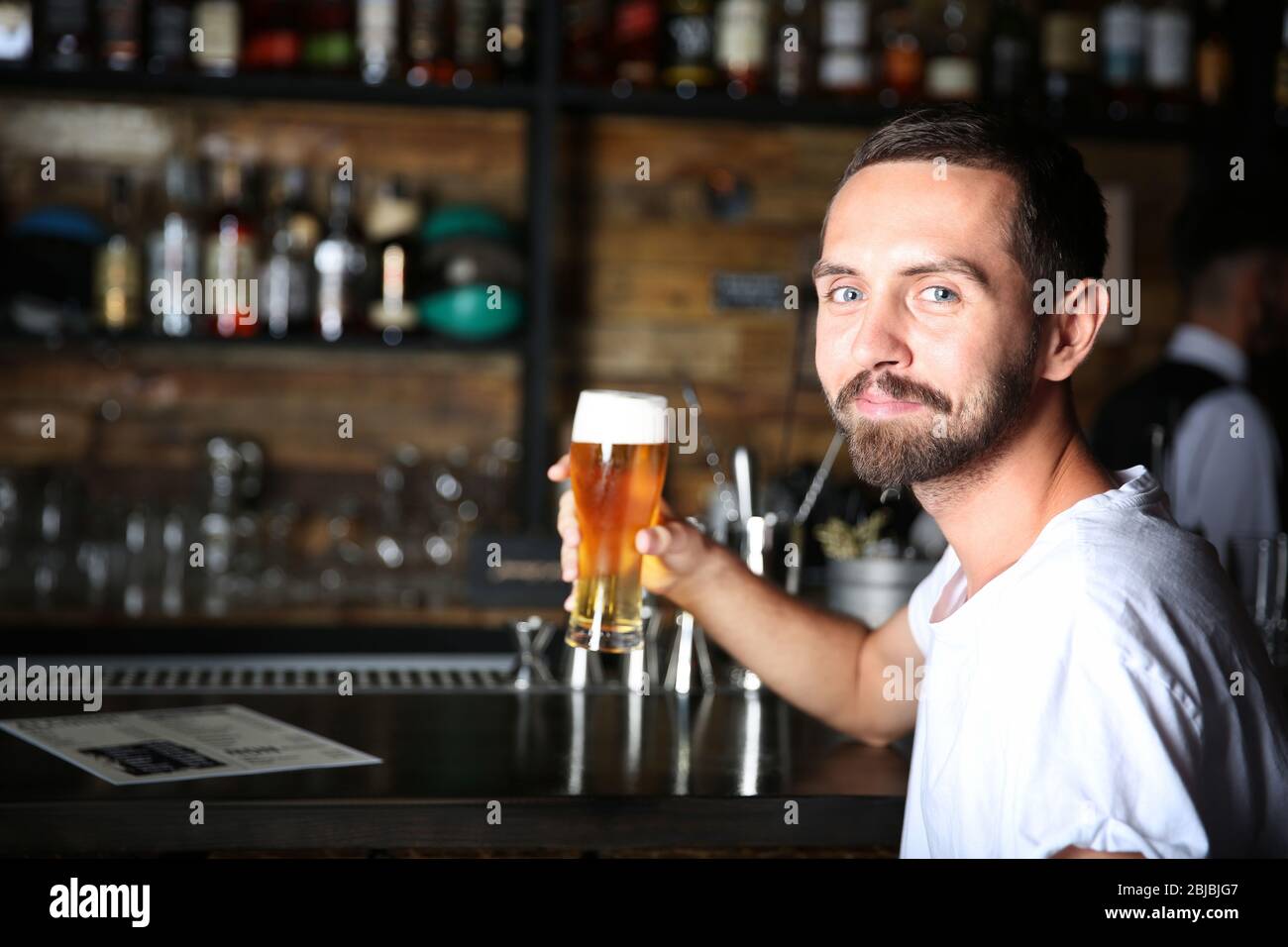 Man drinking beer at bar counter Stock Photo - Alamy