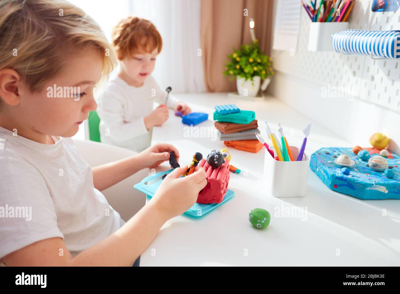cute kids are creating the hand crafts from modelling plasticine at ...