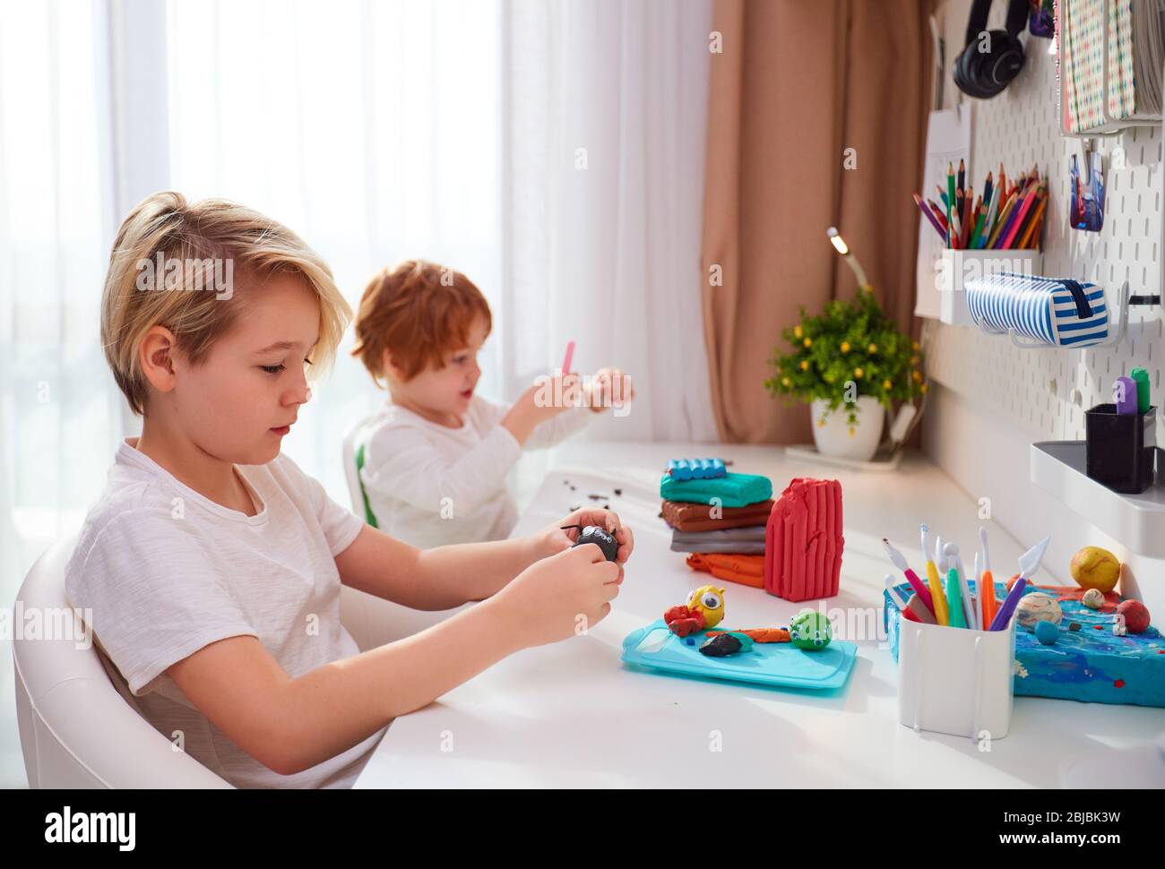 cute kids are creating the hand crafts from modelling plasticine at ...