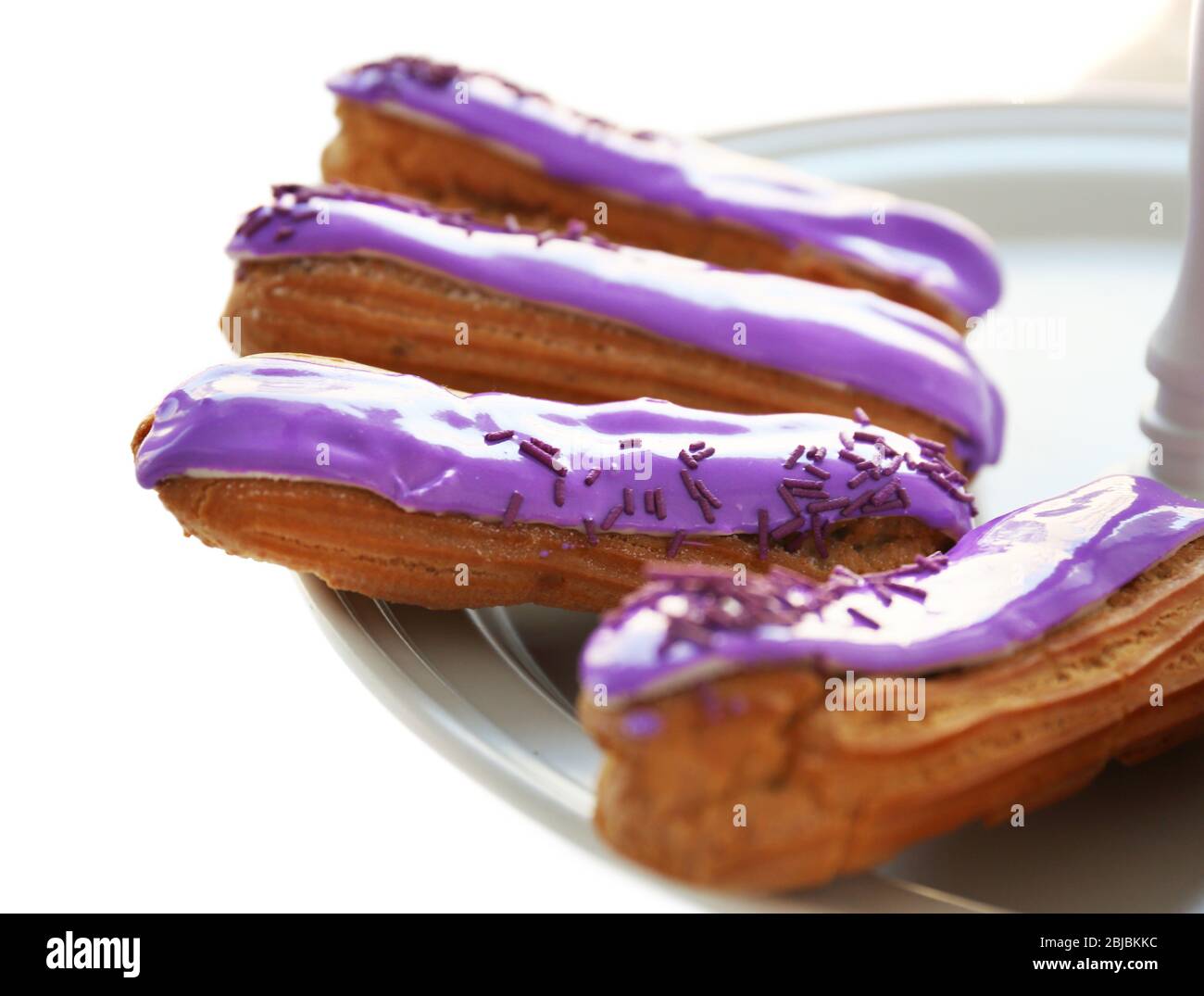 Delicious eclairs on tiered plate closeup Stock Photo - Alamy