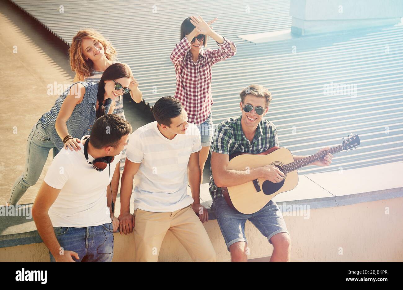 Happy friends playing guitar and singing on street Stock Photo - Alamy