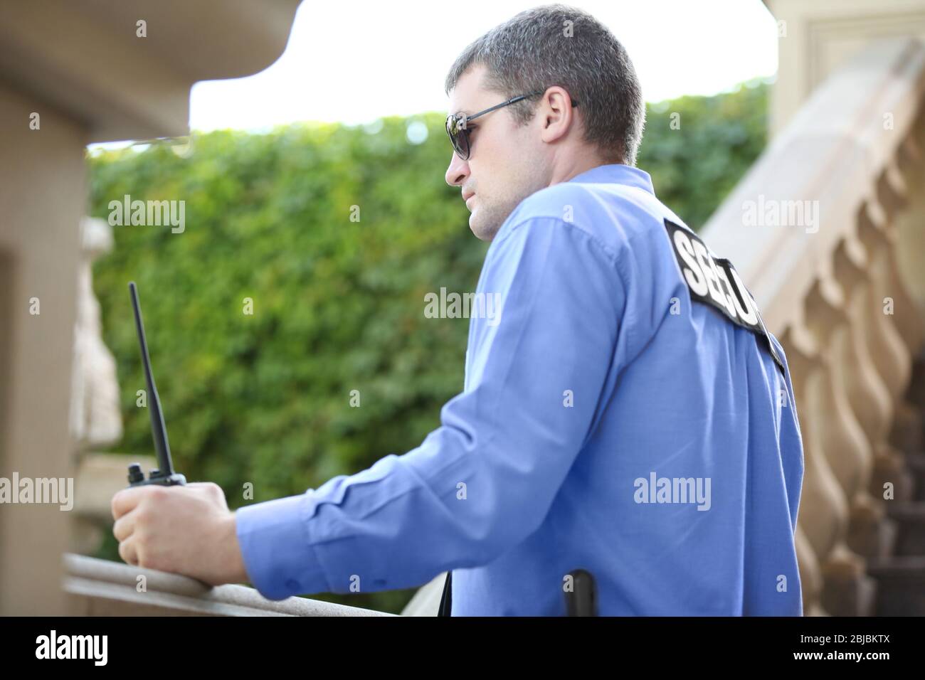 Male security guard protecting house outdoor Stock Photo - Alamy