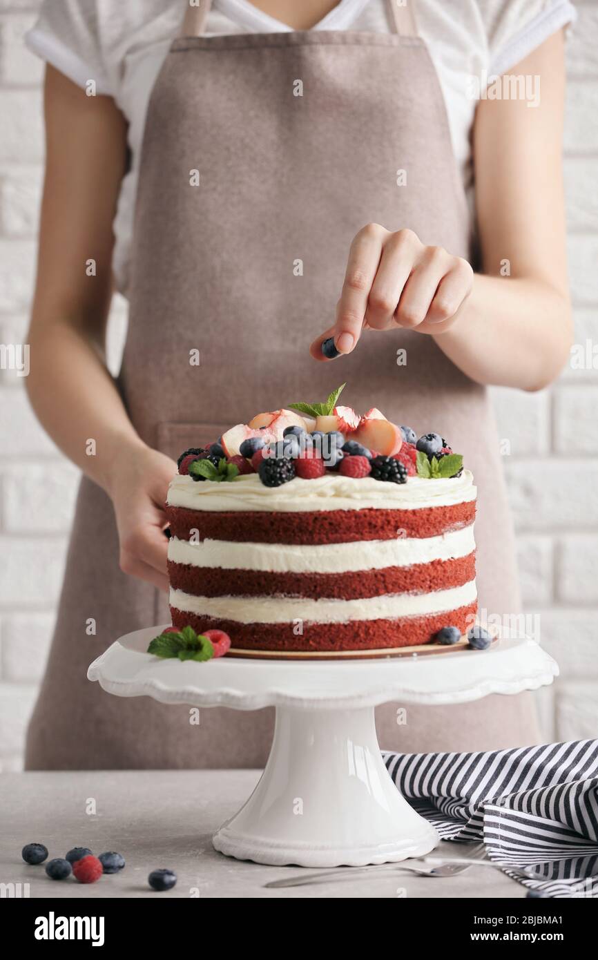 Woman decorating delicious cake Stock Photo - Alamy