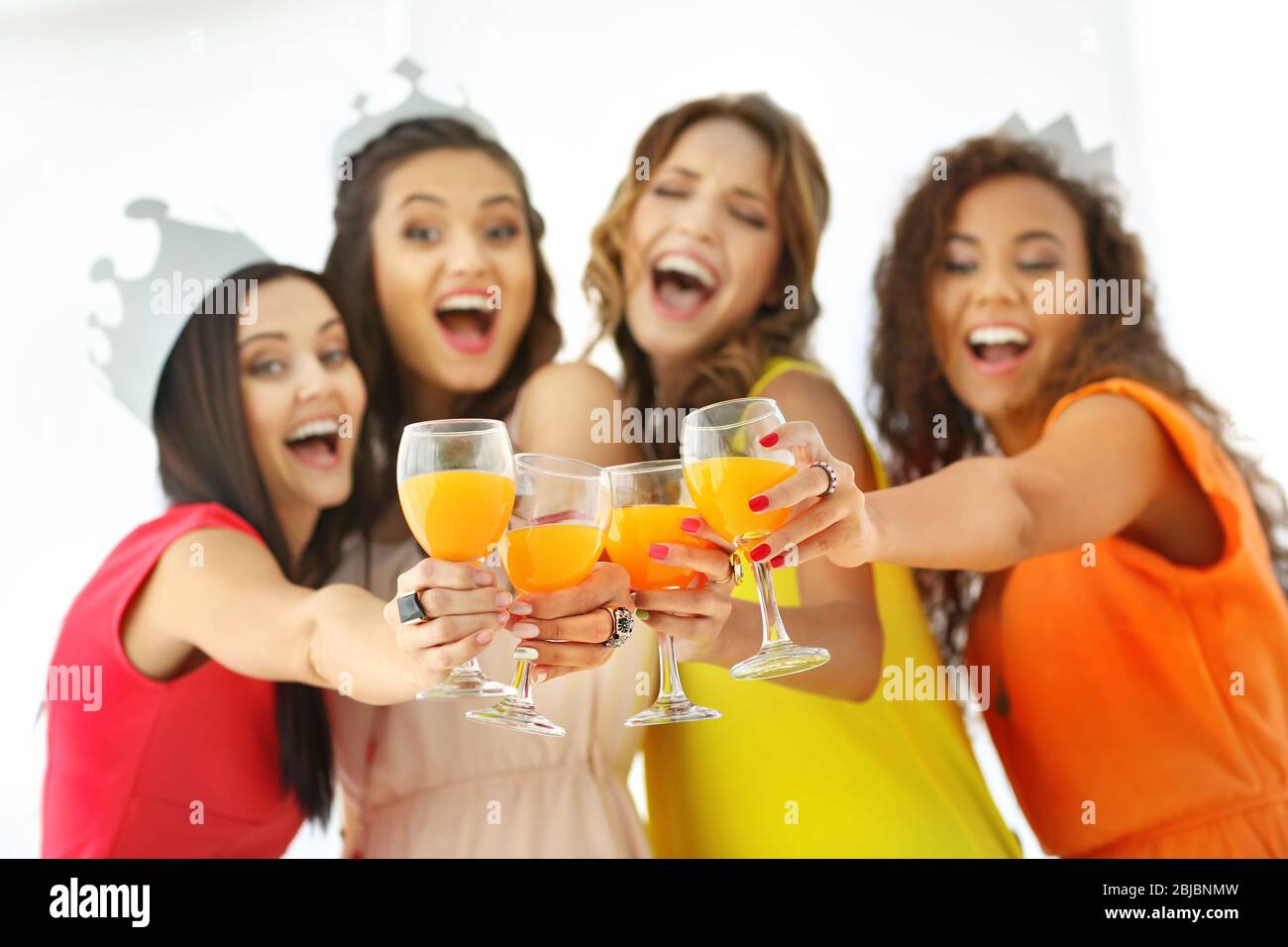 Beautiful girls with cocktails on light background Stock Photo - Alamy