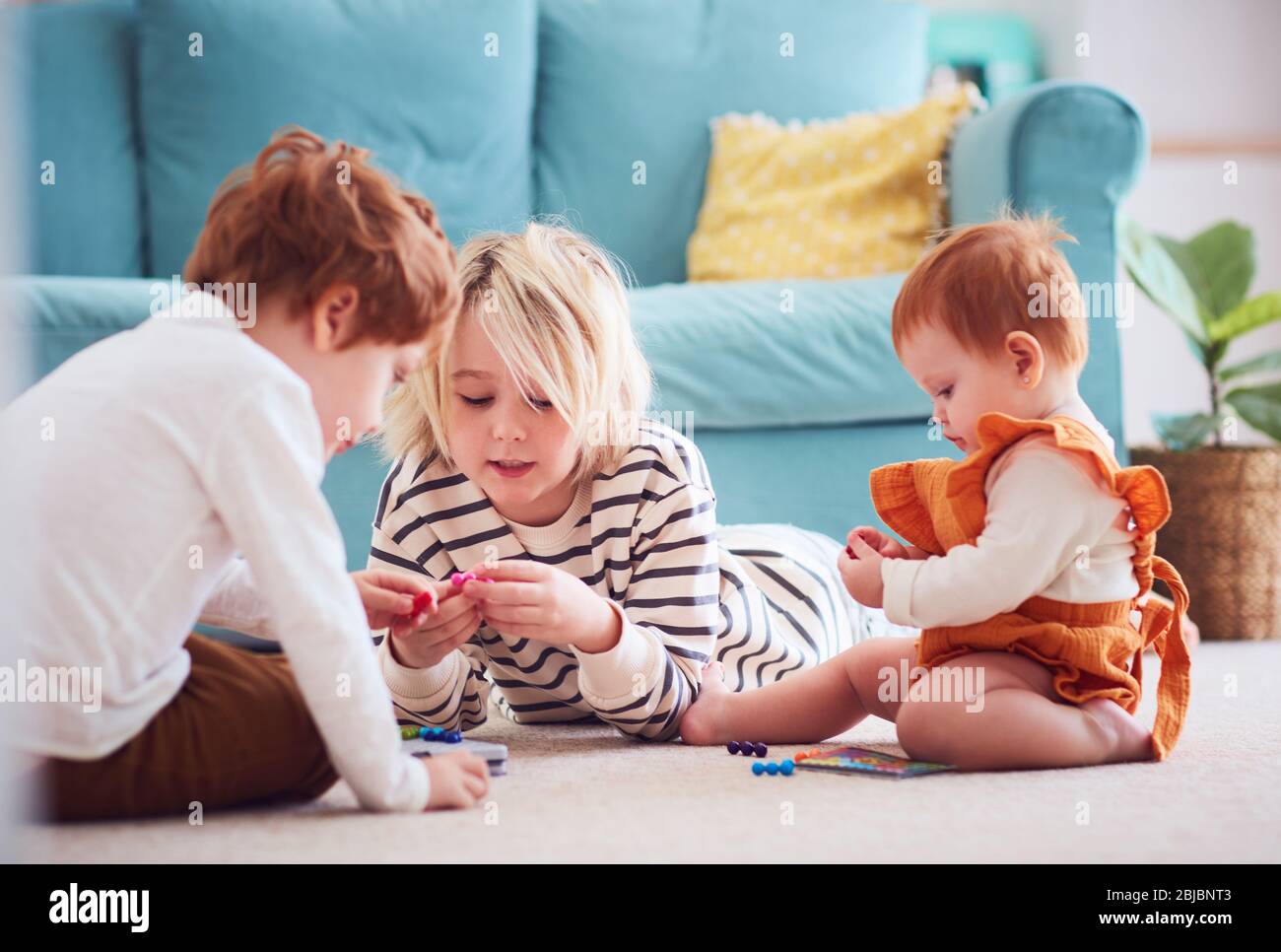 cute kids, siblings playing together on the floor at home Stock Photo ...