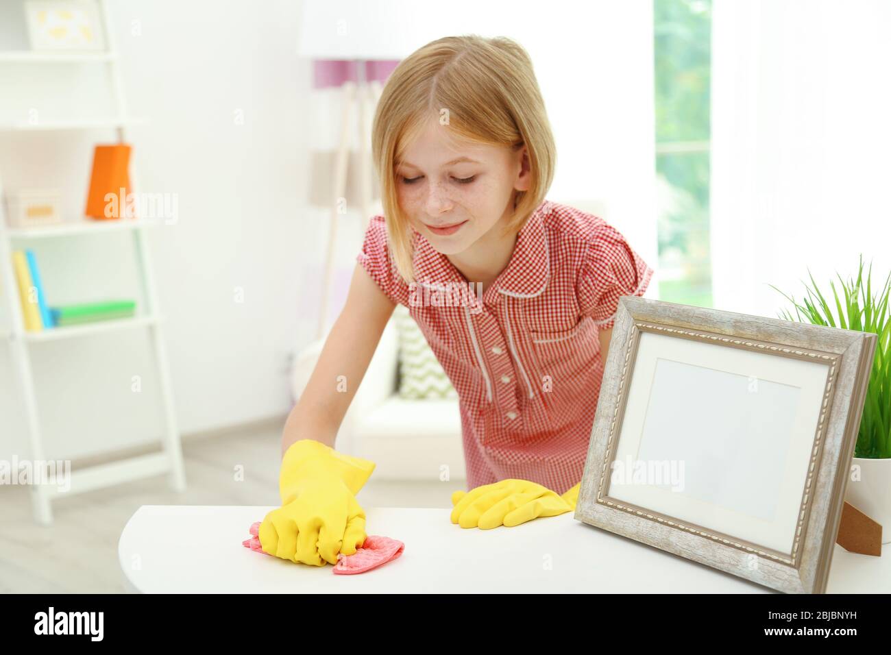 Small girl cleaning table with sponge, indoor Stock Photo - Alamy