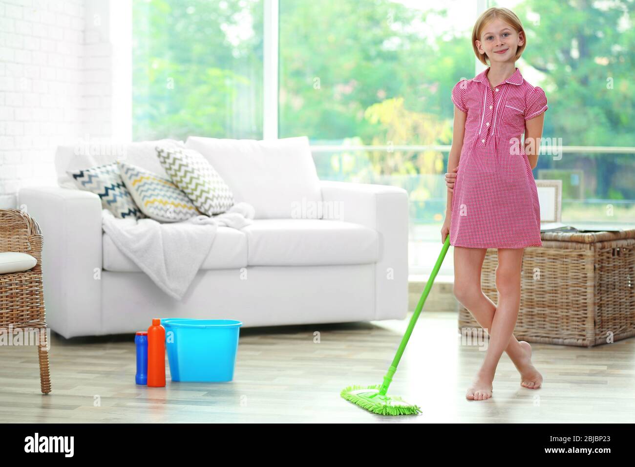 Small girl cleaning room with mop on light background Stock Photo - Alamy