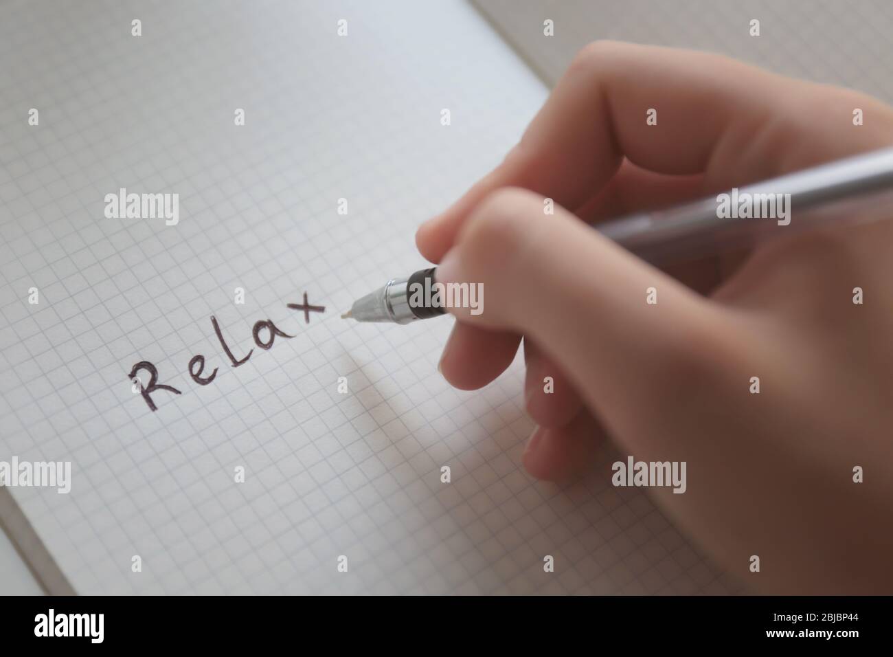 Female hand writing word "relax" in notebook, close up view Stock Photo ...