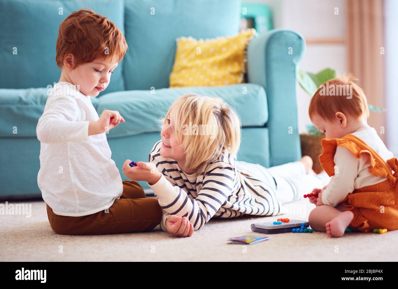 cute kids, siblings playing together on the floor at home Stock Photo ...