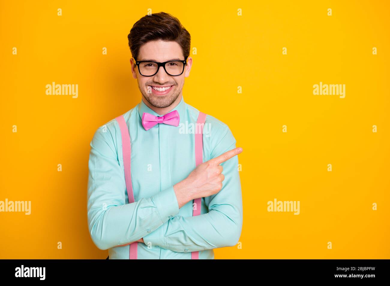 Portrait of positive cheerful man point index finger direct way ads ...