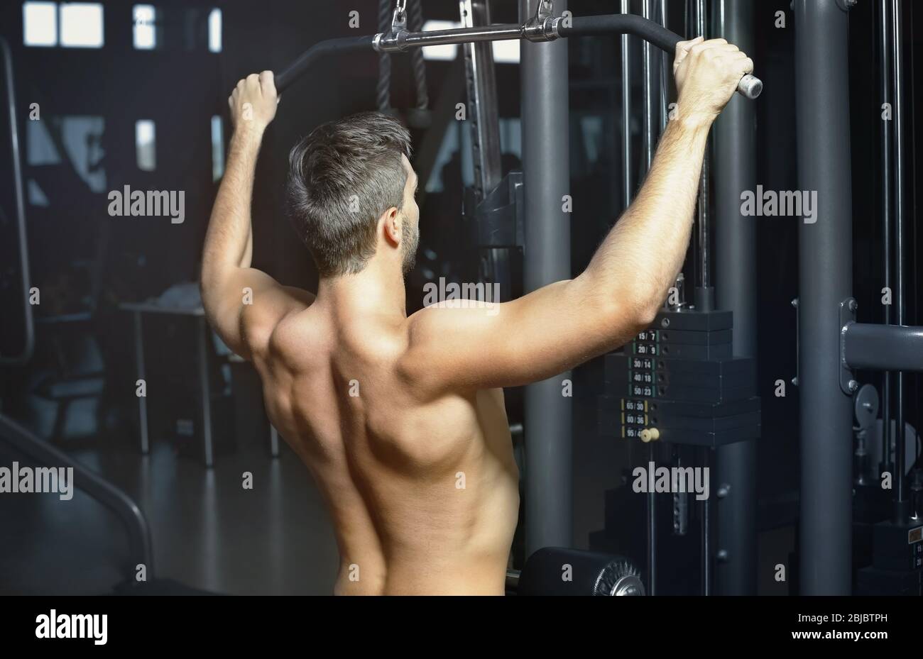 Athletic man training back muscles in gym Stock Photo - Alamy