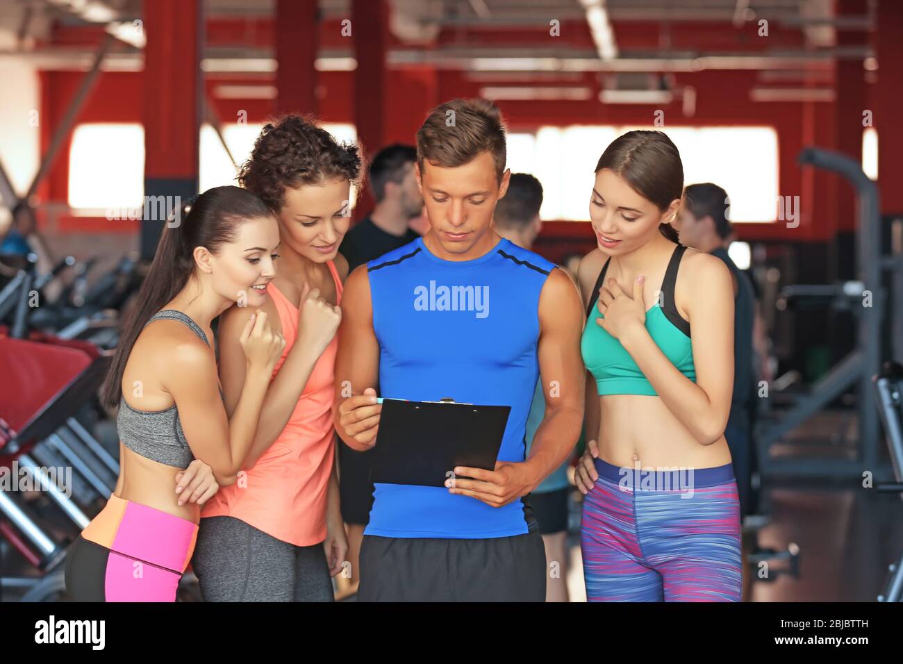 Group of women with personal trainer in gym Stock Photo - Alamy