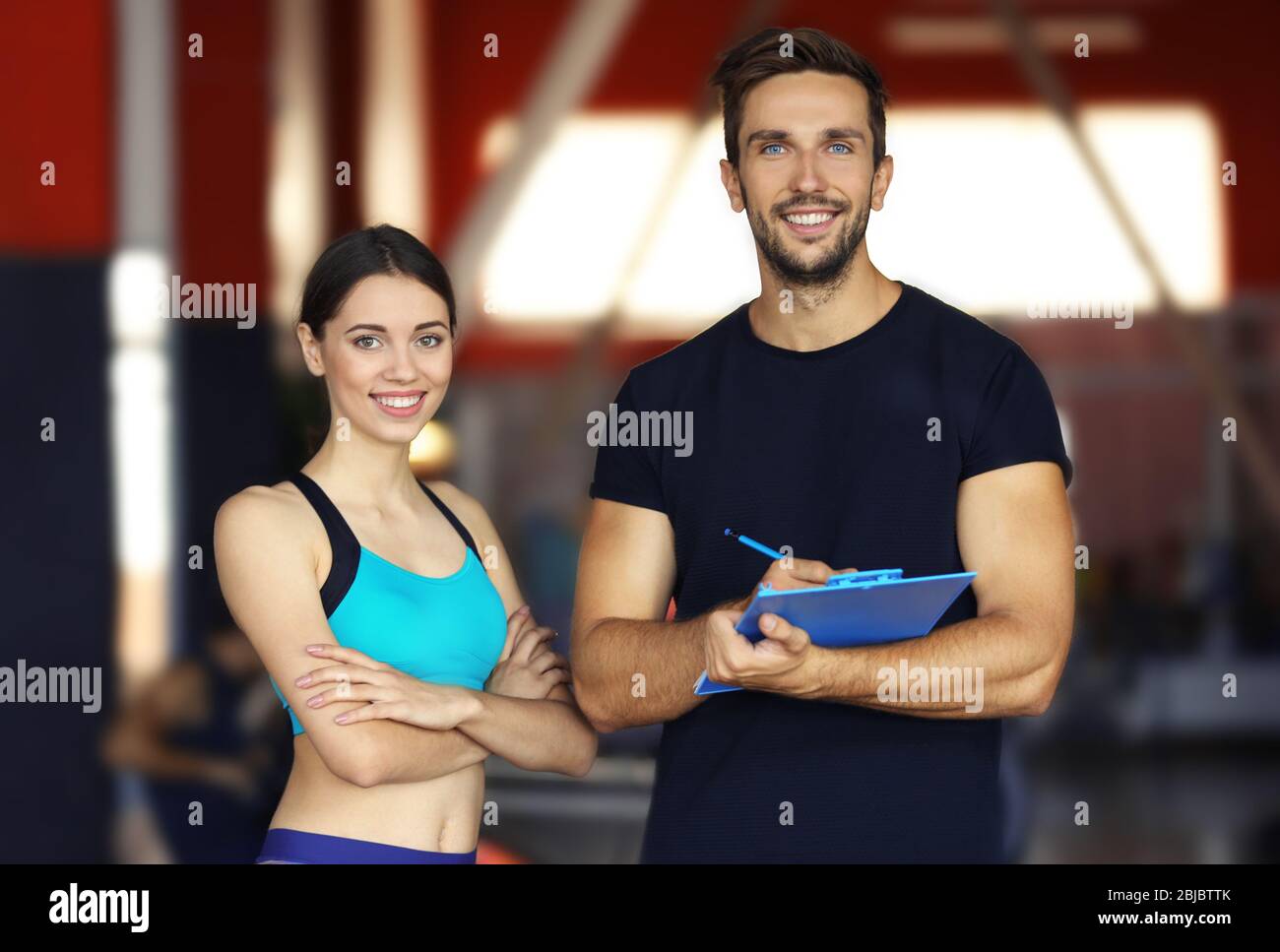 Woman with personal trainer preparing training plan in gym Stock Photo ...