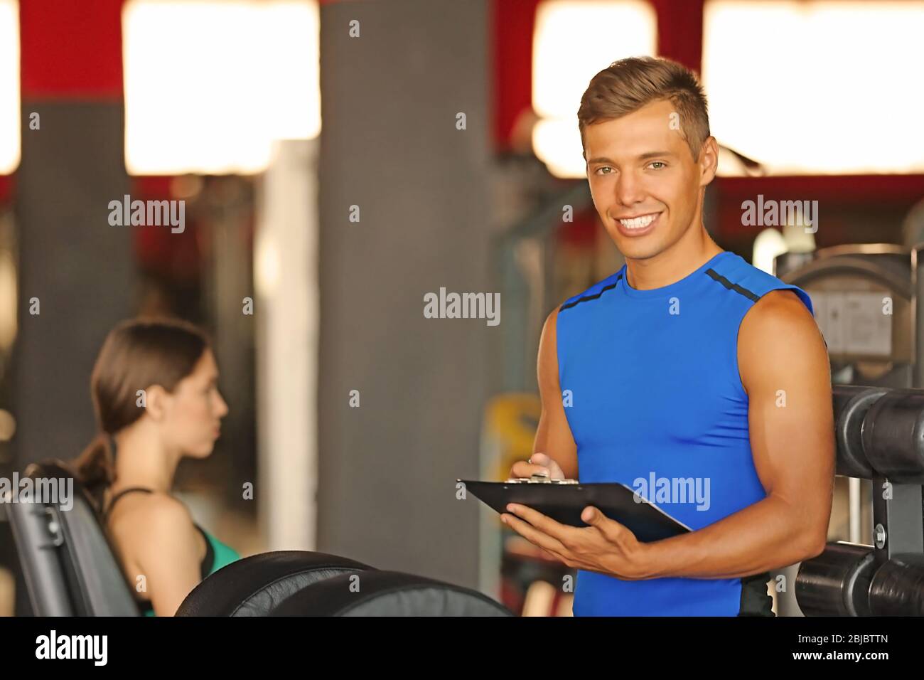 Portrait of personal trainer holding clipboard with training plan in ...