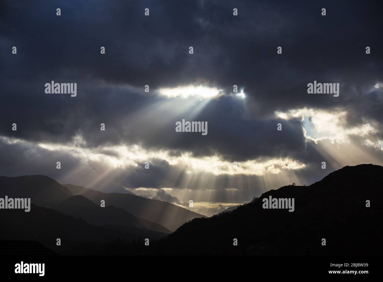 Crepuscular rays over Ambleside at sunset, Lake District, UK Stock ...