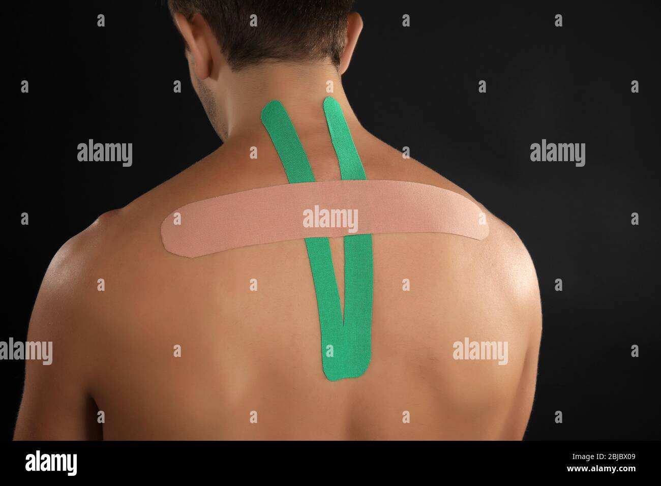 Male back with applied physio tape, on black background Stock Photo - Alamy