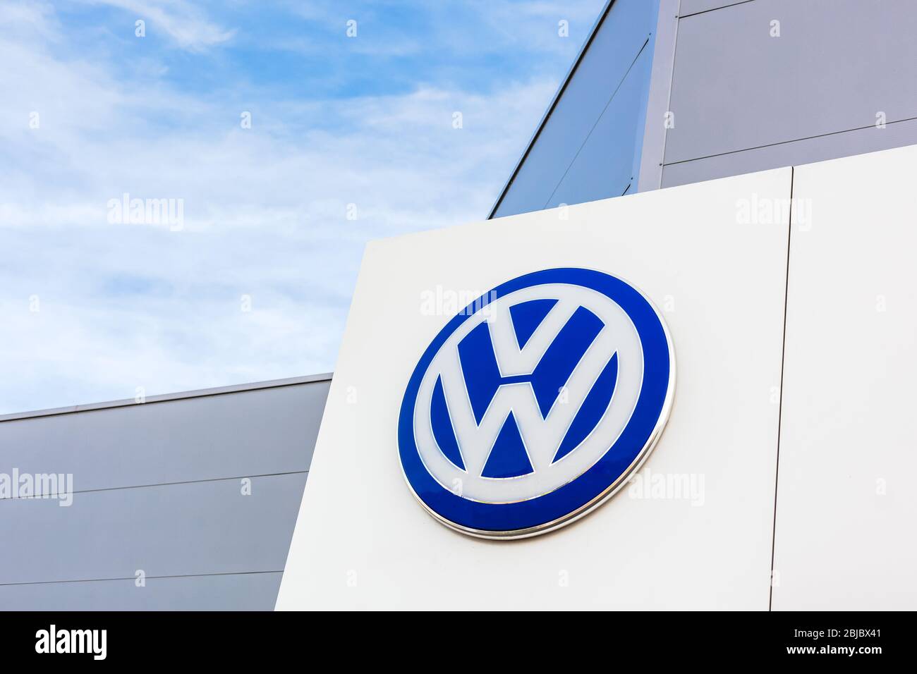 Volkswagen brand logo on bright blue sky background located on its ...