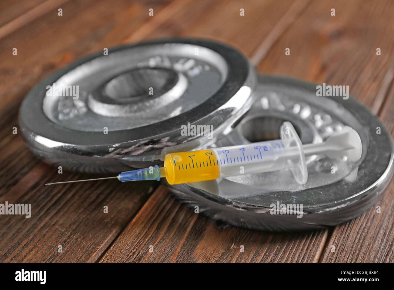 Weight disks and syringe on wooden background Stock Photo - Alamy