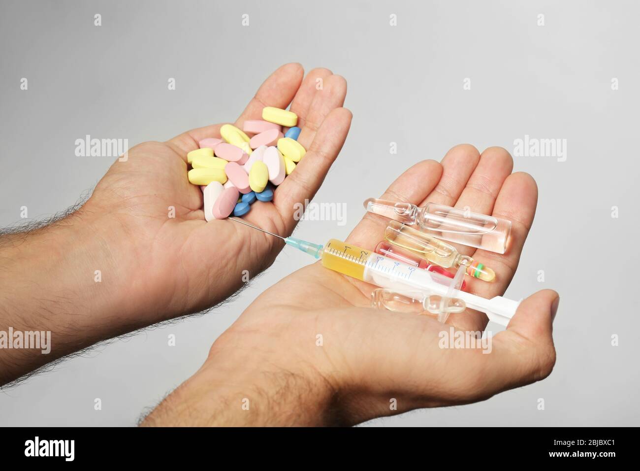 Male hands holding syringe and drugs on light background Stock Photo ...